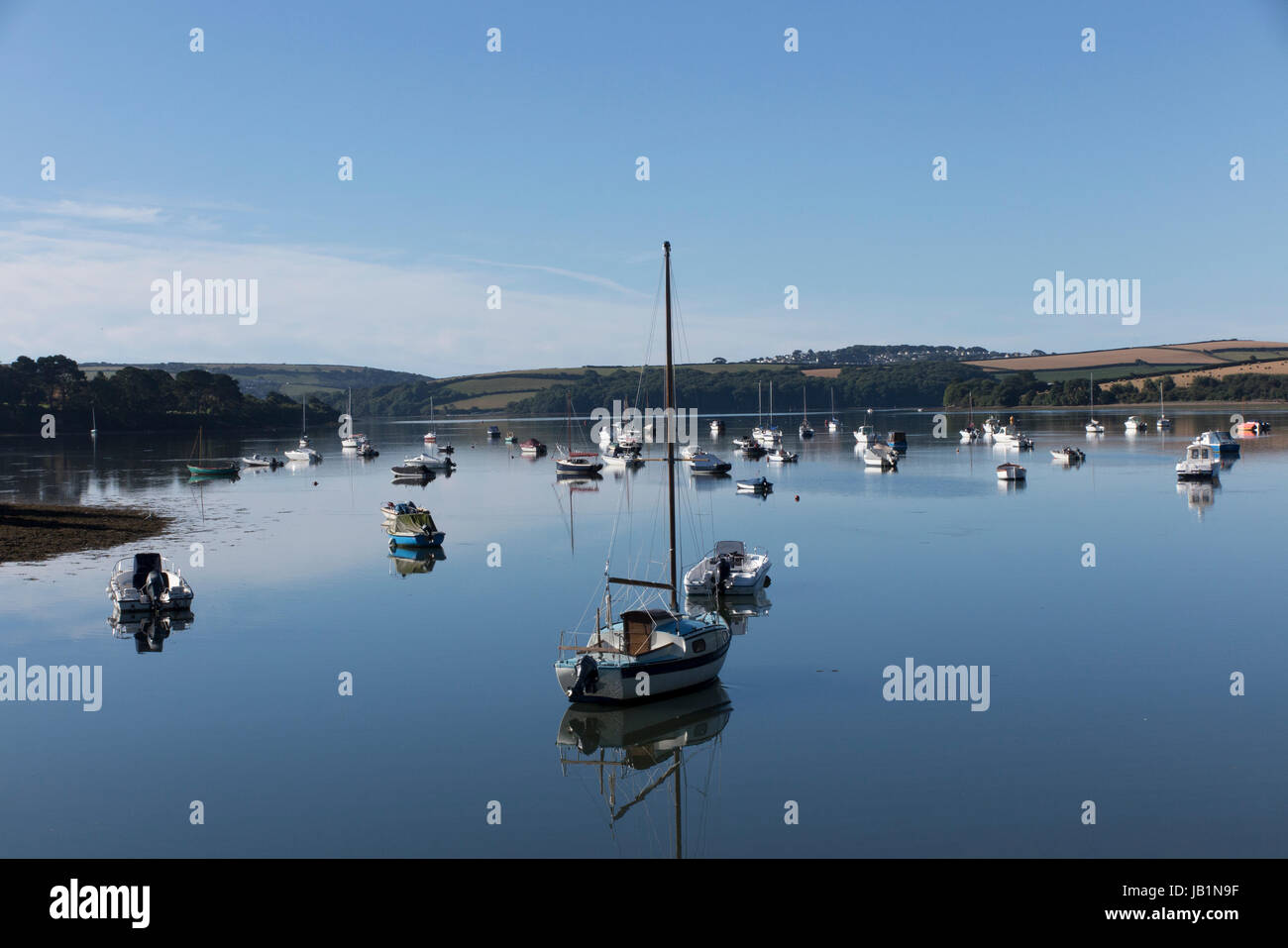 Kingsbridge Estuary in South Devon, UK. Boats reflected in calm water ...