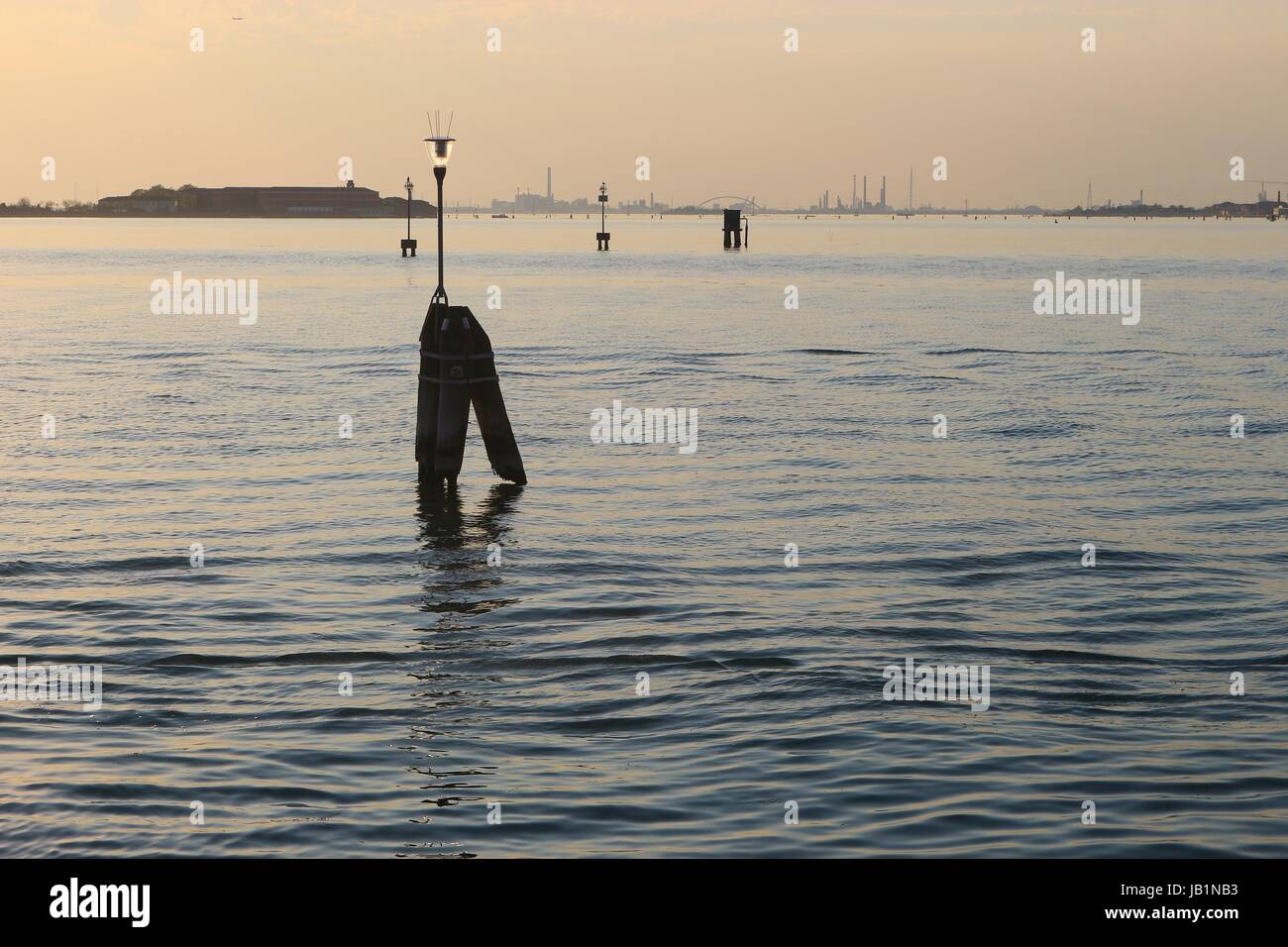 The lagoon of Venice at sunset, a breakwater in the foreground. In the ...
