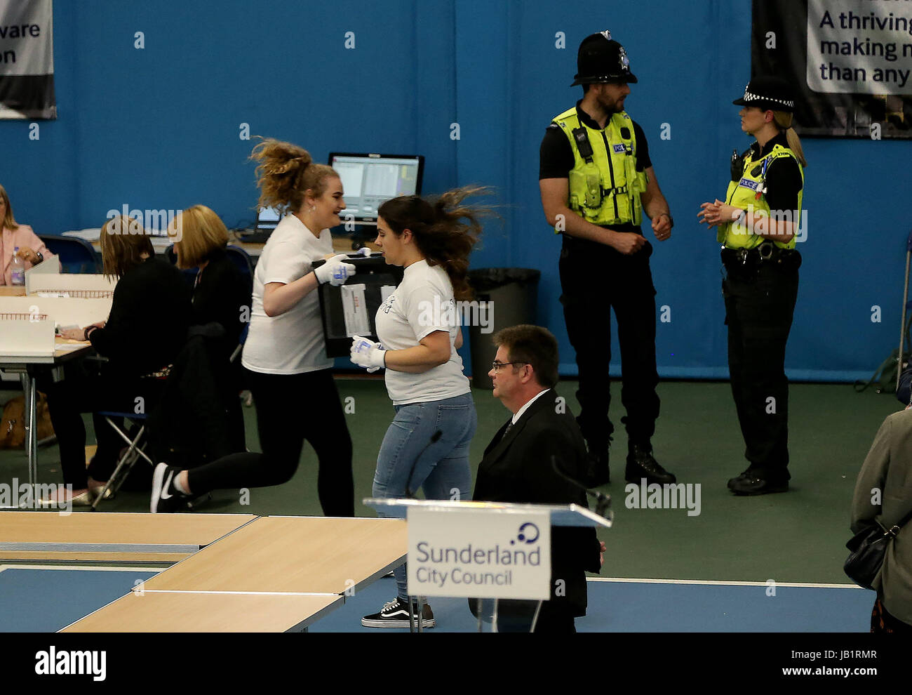 Election staff run with ballot boxes as the General Election count gets ...