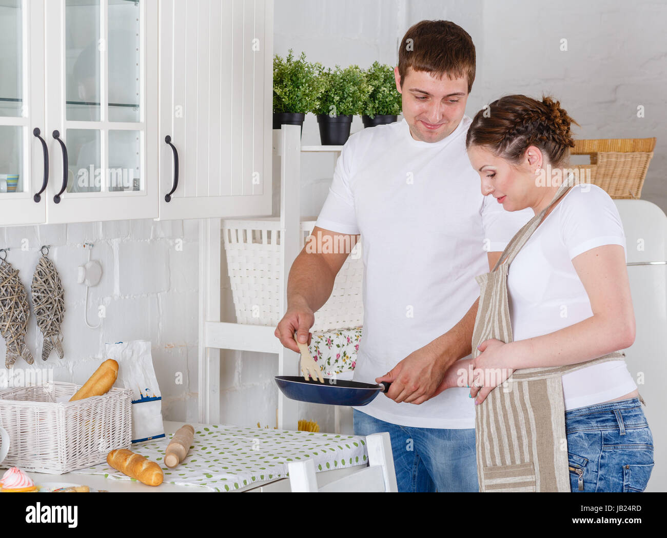 Happy pregnant woman and her husband cook food in the kitchen Stock ...