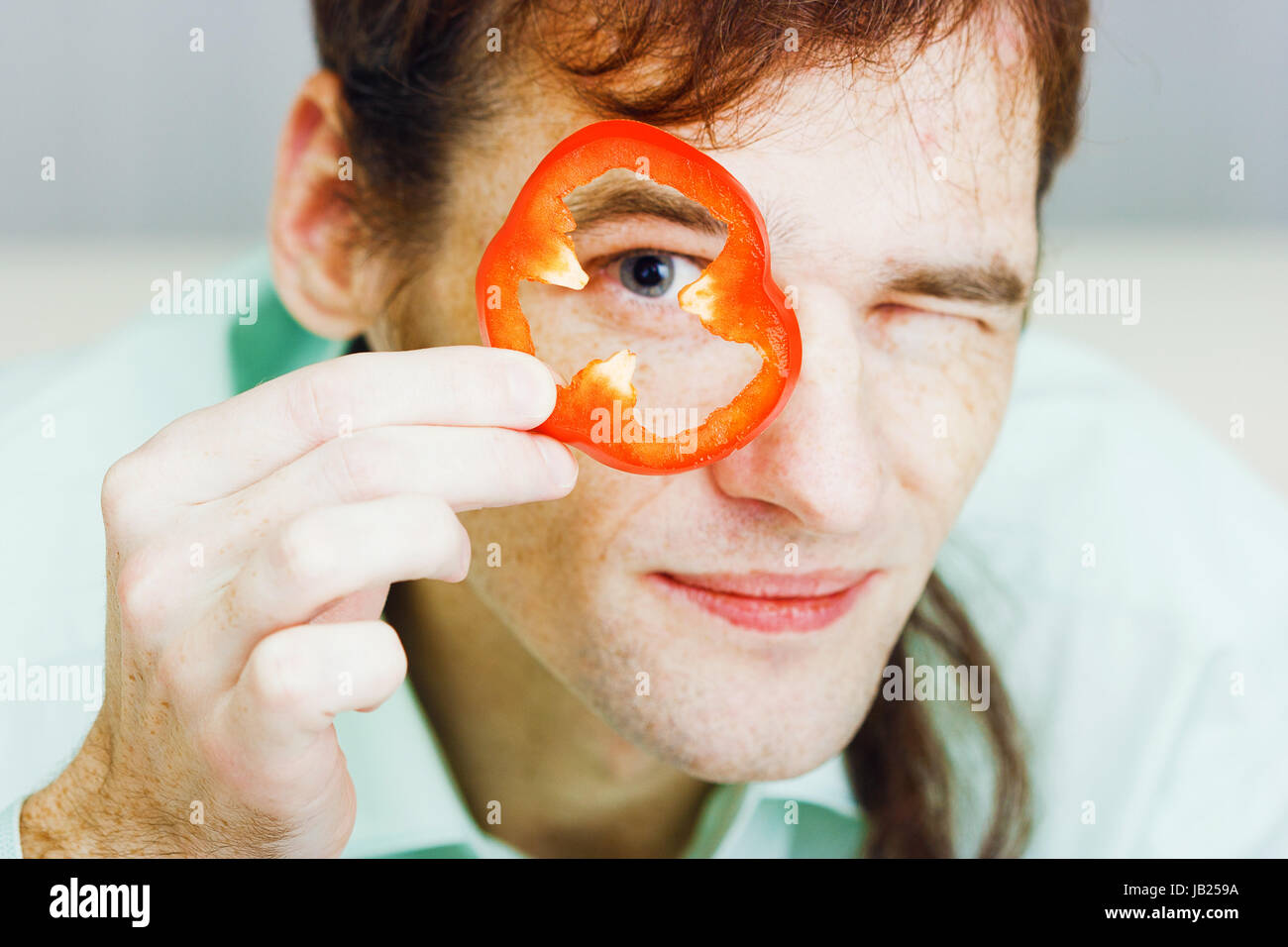 Young man with red pepper. Face close-up. humor Stock Photo - Alamy
