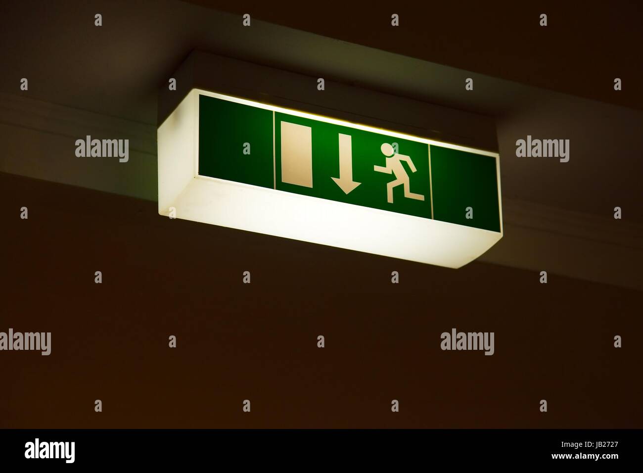 Emergency exit sign glowing in the dark Stock Photo - Alamy