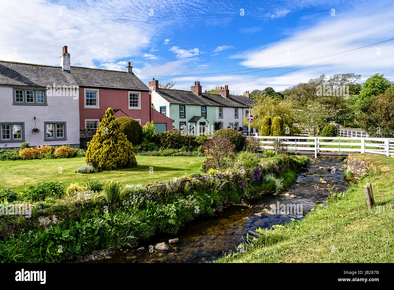 Quaint coloured houses by the beck in Caldbeck, Cumbria Stock Photo - Alamy