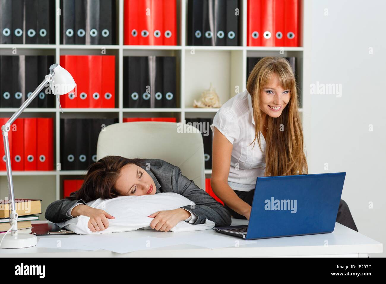 Tired young business woman is sleeping on workplace in the office ...