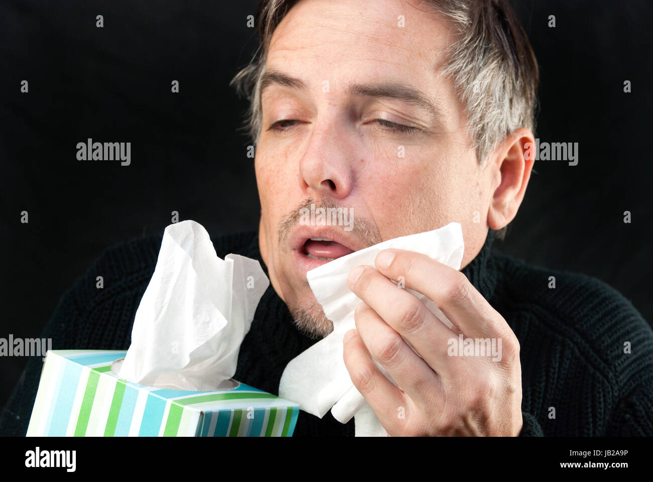 Close-up of a man about to sneeze holding a tissue and the box Stock ...