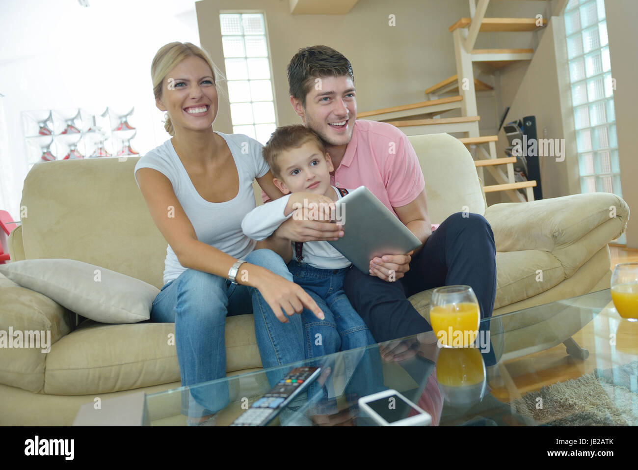 happy young family using tablet computer at modern home for playing ...