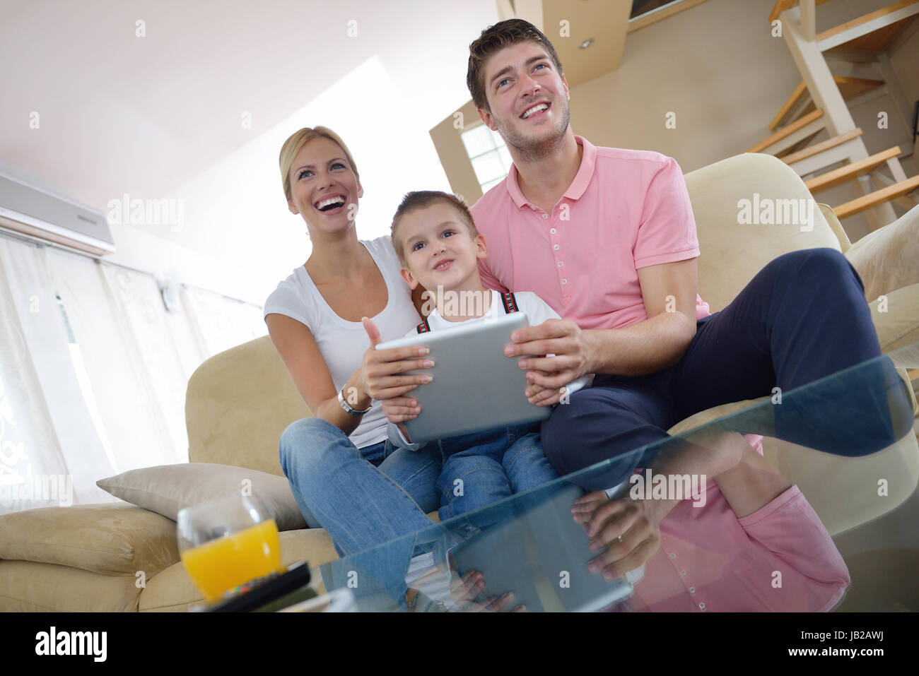 happy young family using tablet computer at modern home for playing ...