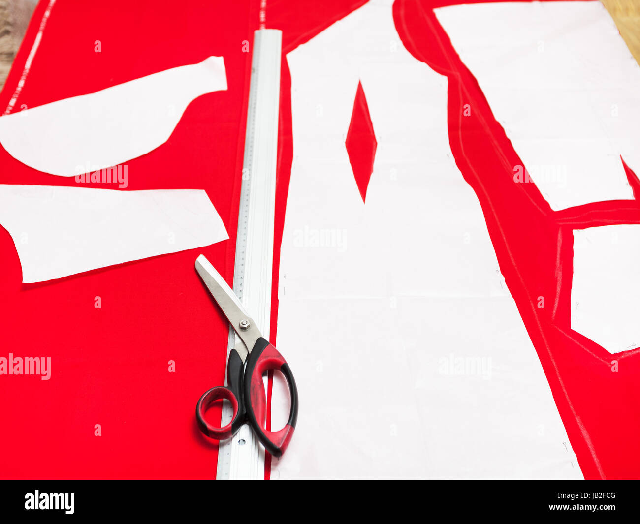 fitter scissors, ruler and cutting out woolen fabric along pattern ...