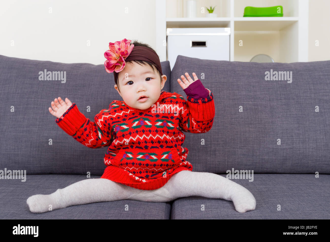 Baby girl doing legs splits on sofa Stock Photo - Alamy