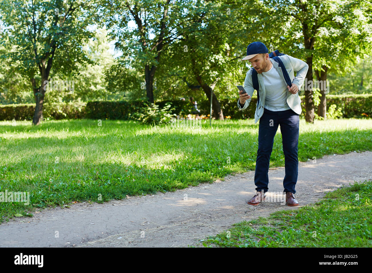 Walking in Park with Smartphone Stock Photo - Alamy