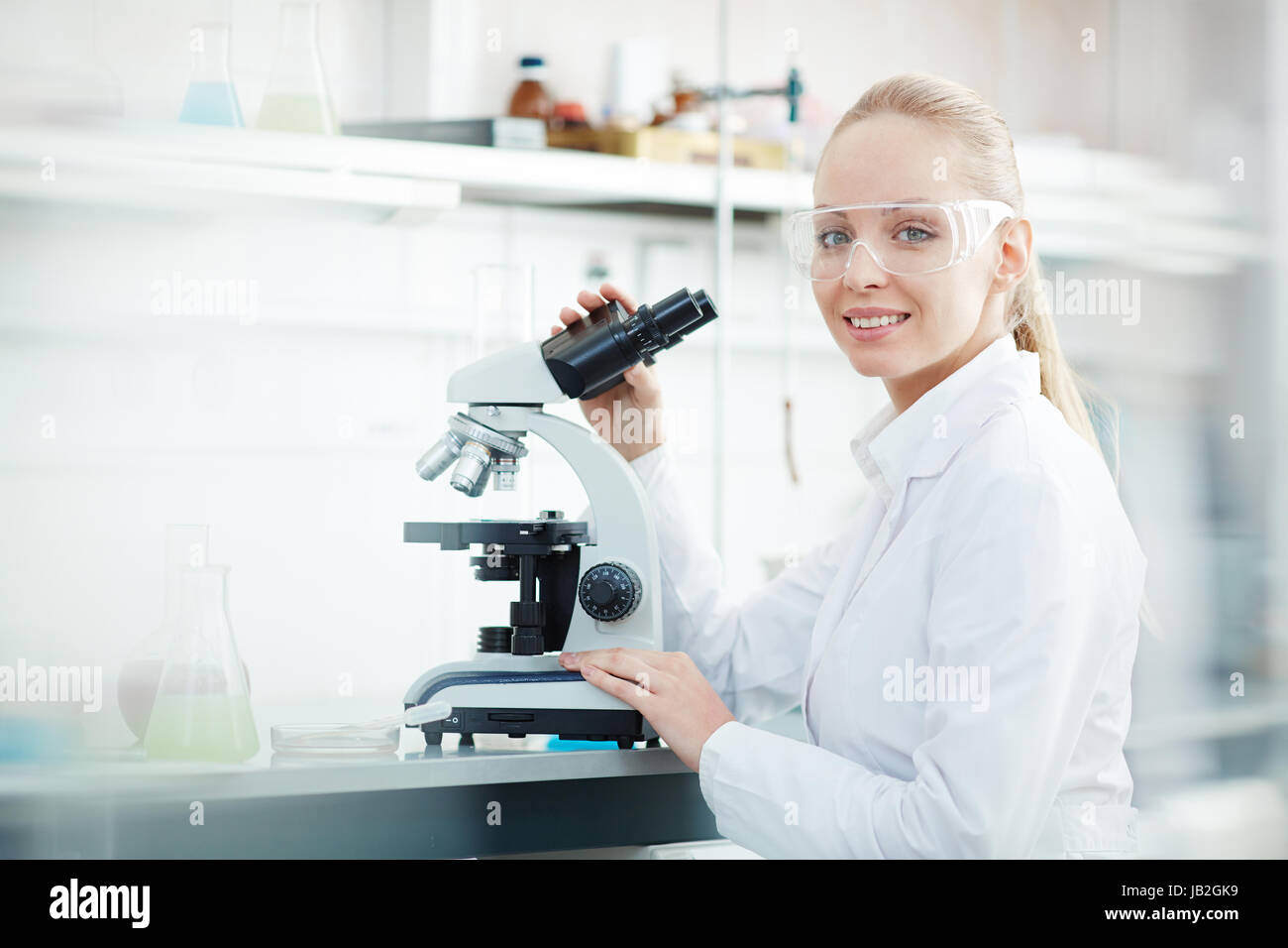 Smiling Woman Using Microscope in laboratory Stock Photo - Alamy