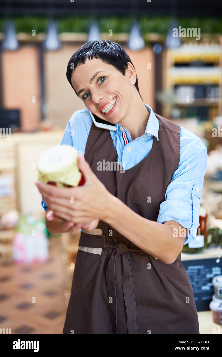 Smiling Shop Owner Wrapped up in Work Stock Photo - Alamy