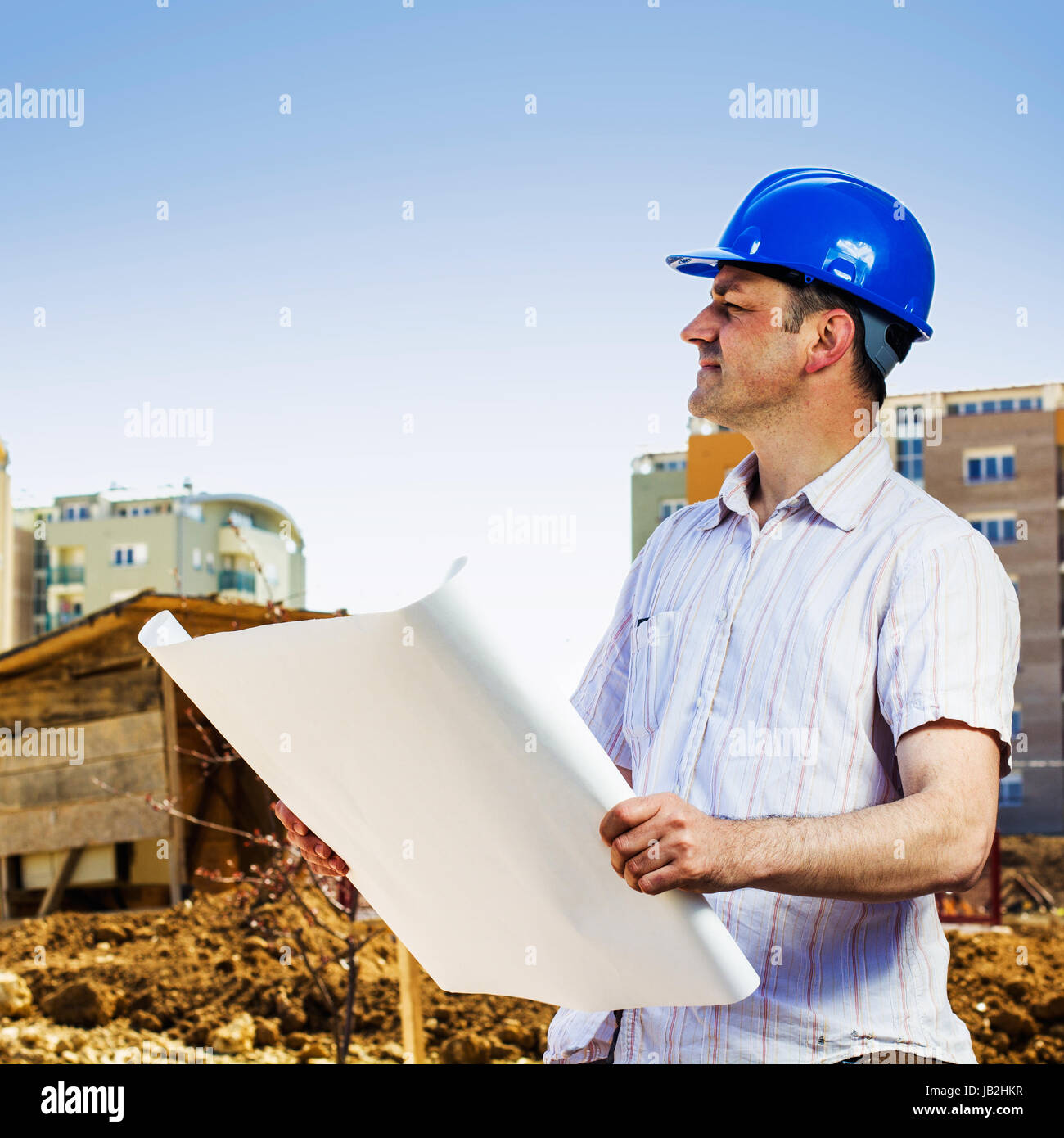 Architect holding blueprint at the construction site Stock Photo - Alamy
