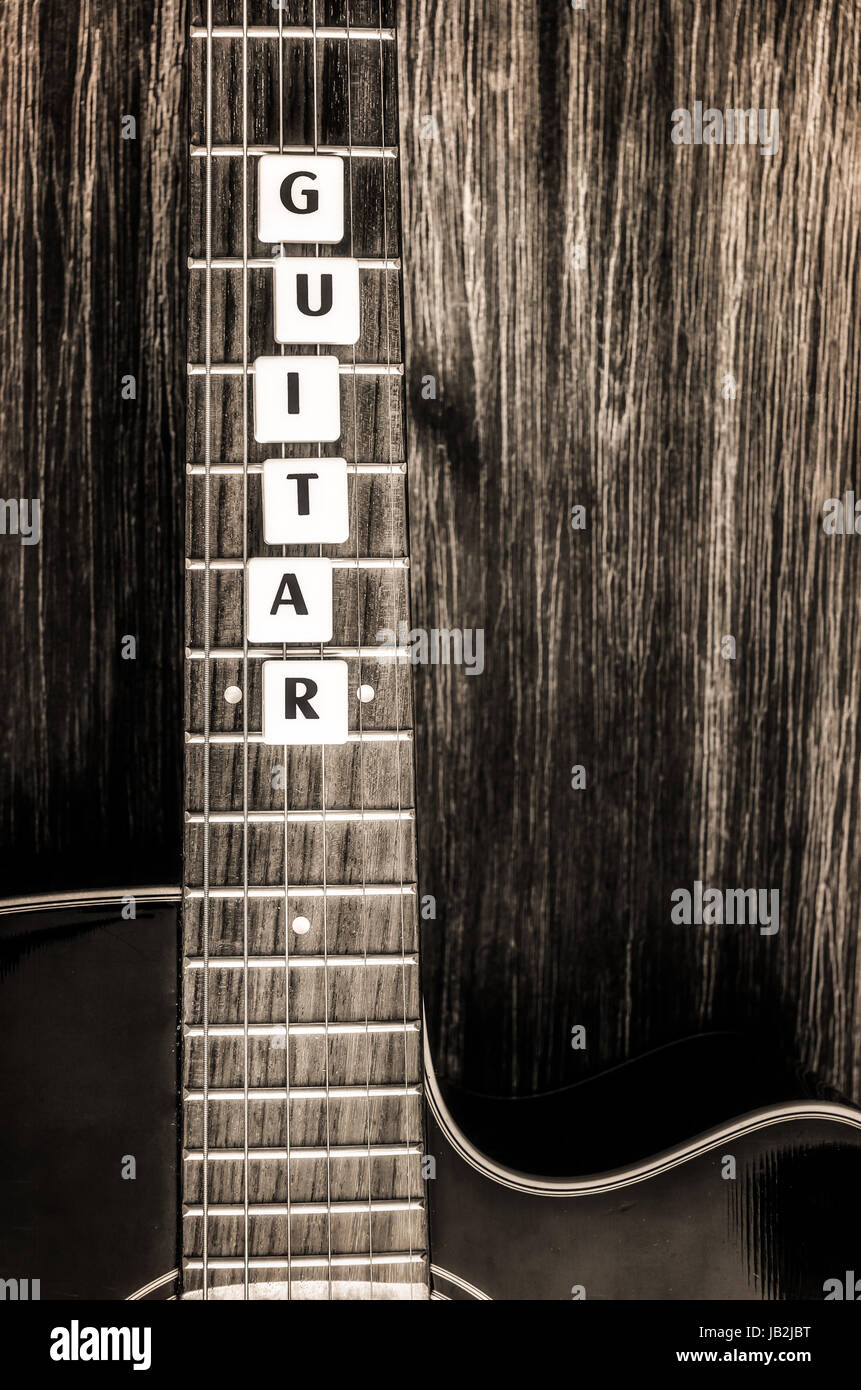 Acoustic guitar in vintage style on wood texture background Stock Photo ...