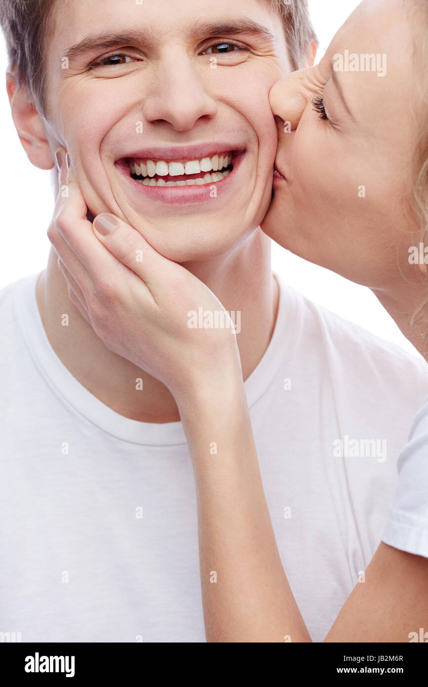Handsome guy looking at camera with pretty girl kissing him Stock Photo ...