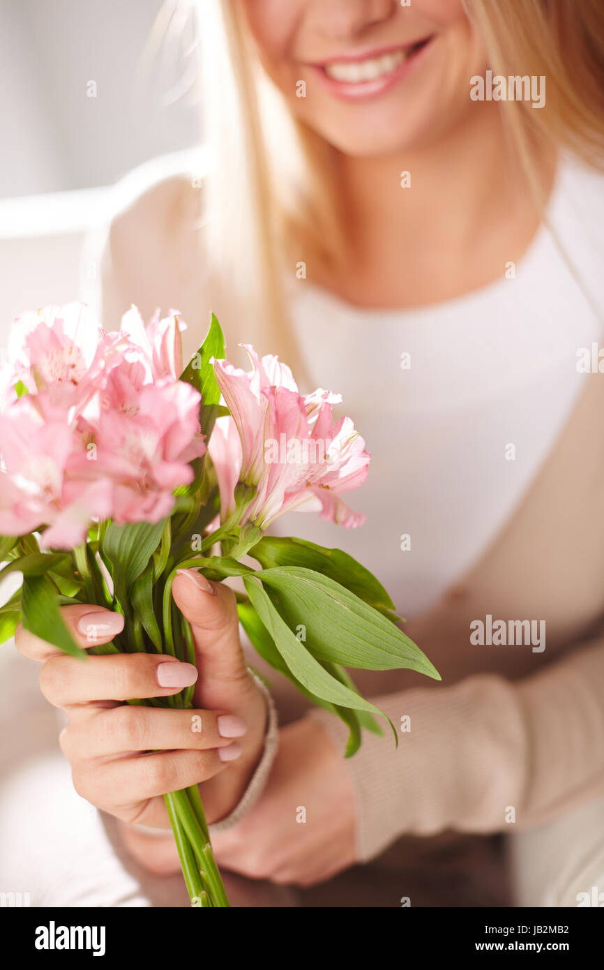Close-up of smiling female holding bunch of pink lilies Stock Photo - Alamy