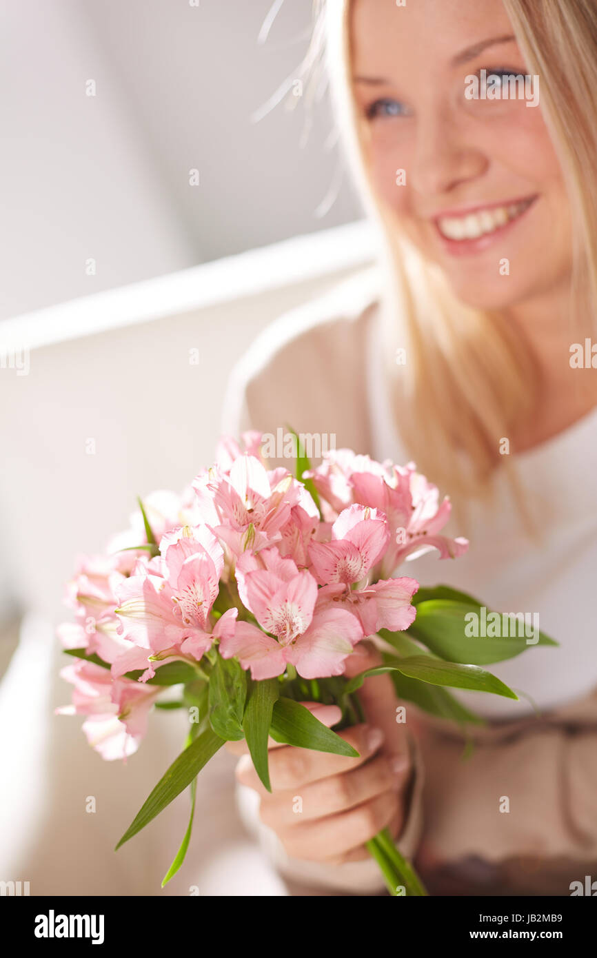 Close-up of smiling female holding bunch of pink lilies Stock Photo - Alamy