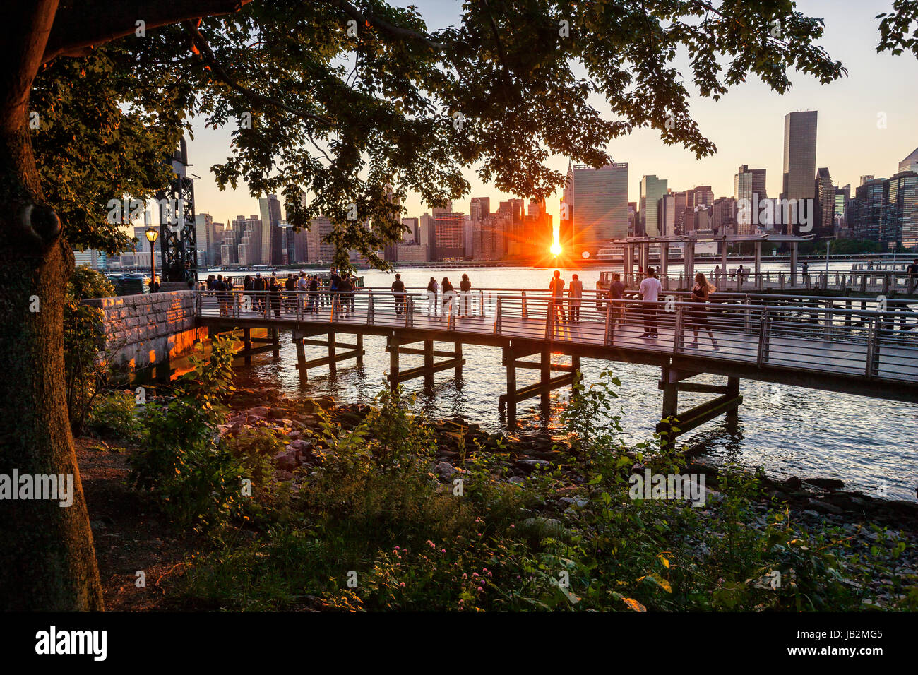 People watching sunset between buildings on Manhattan in New York City ...