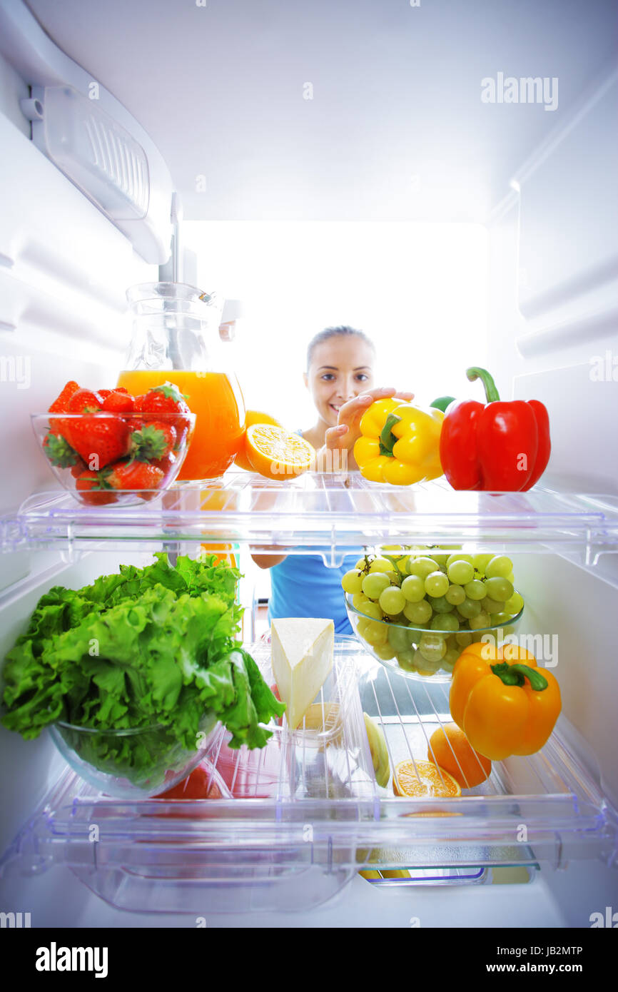Woman reaching for food in refrigerator, view from inside Stock Photo ...