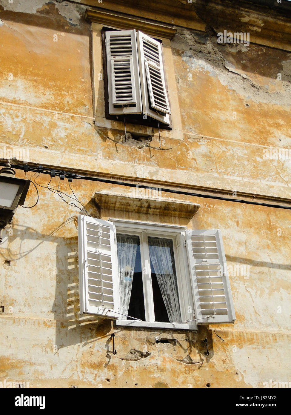 an old house is showing an open and a closed window. taken in Croatia ...