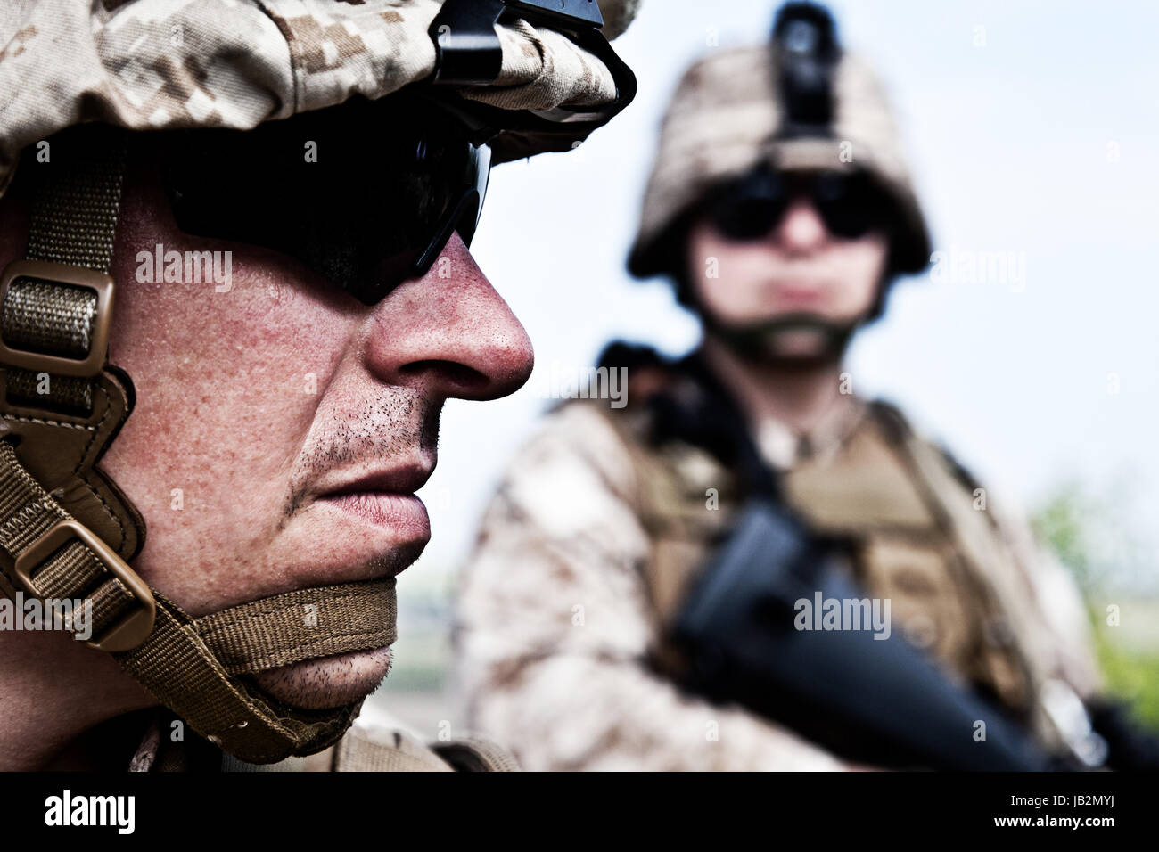 US marine half-turned to the camera. His brother-soldier looking ...