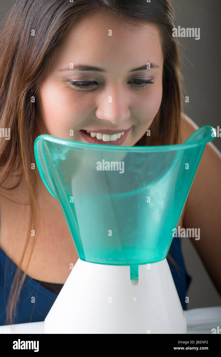 Young woman doing inhalation with a medical vaporizer nebulizer machine ...