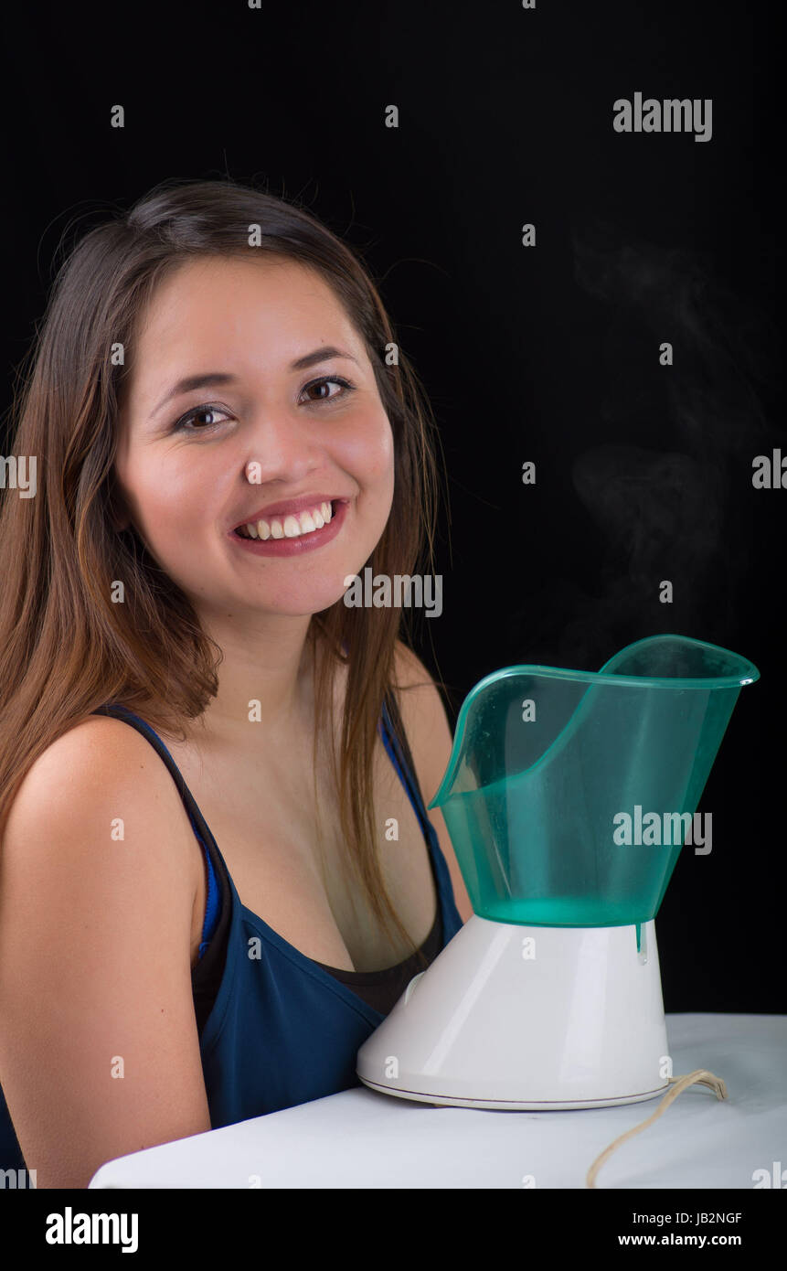 Young woman posing for camera behind of a medical vaporizer nebulizer ...