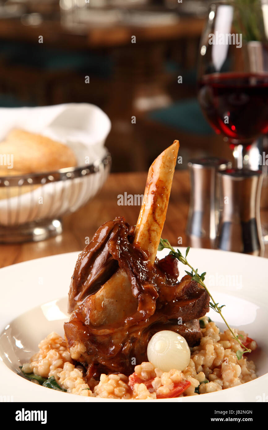 Restaurant table with lamb shank served Stock Photo - Alamy