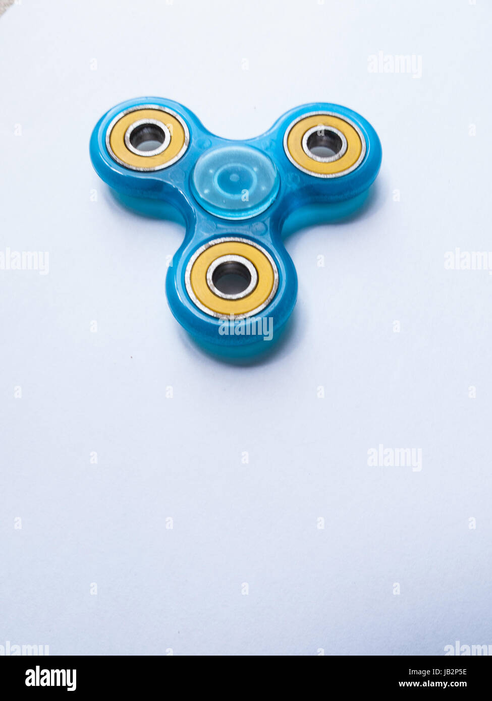 A blue fidget spinner isolated on a white background Stock Photo - Alamy