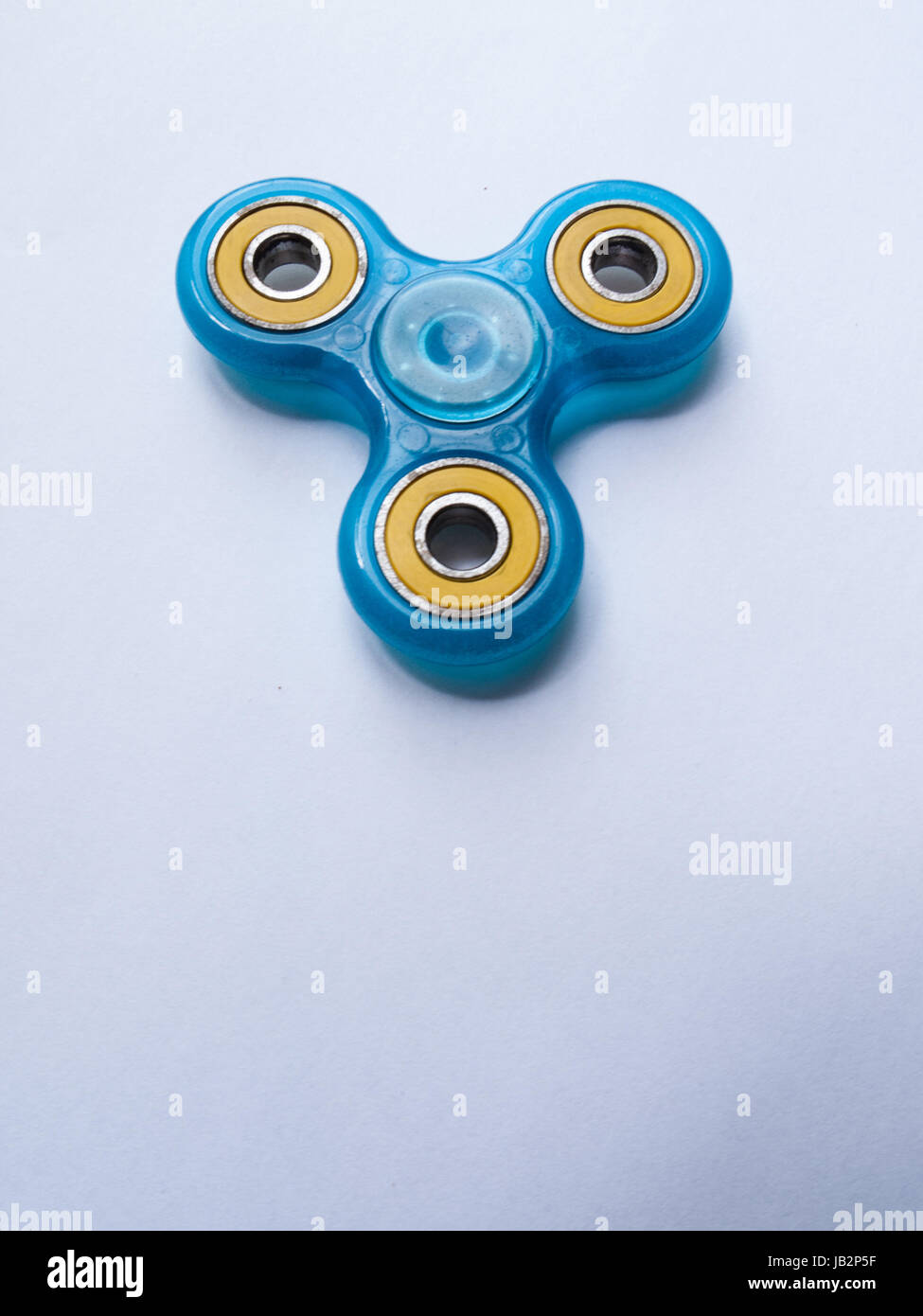 A blue fidget spinner isolated on a white background Stock Photo - Alamy