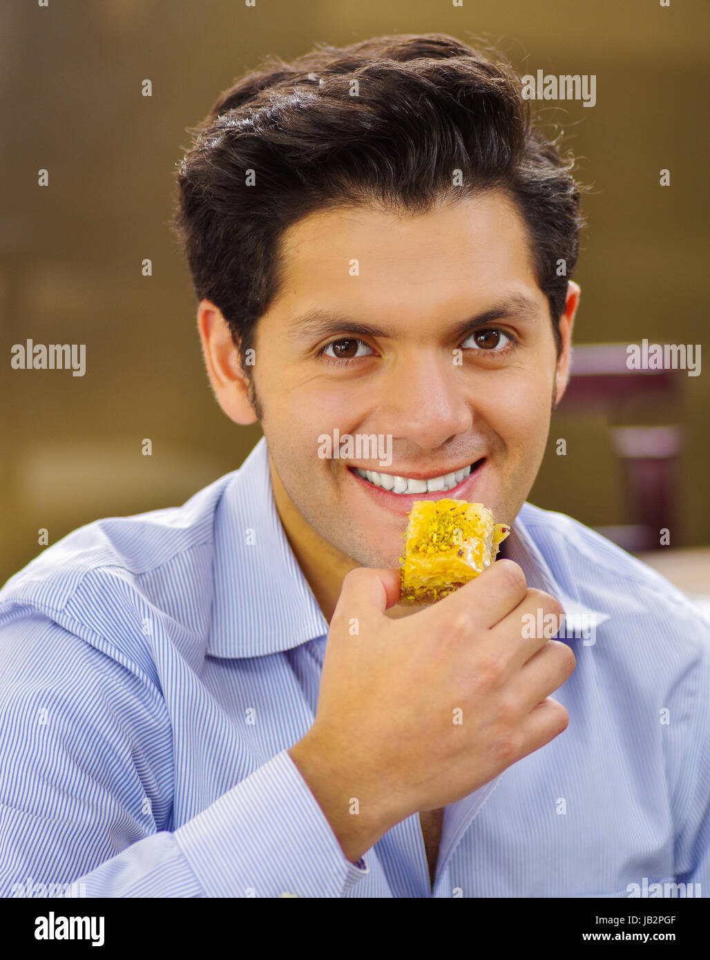 Handsome man eating a delicious traditional turkish food baklava on a ...