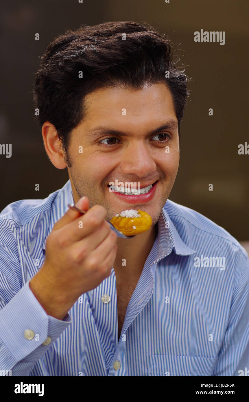 Handsome man eating a delicious turkish dessert sekerpare with coconut ...
