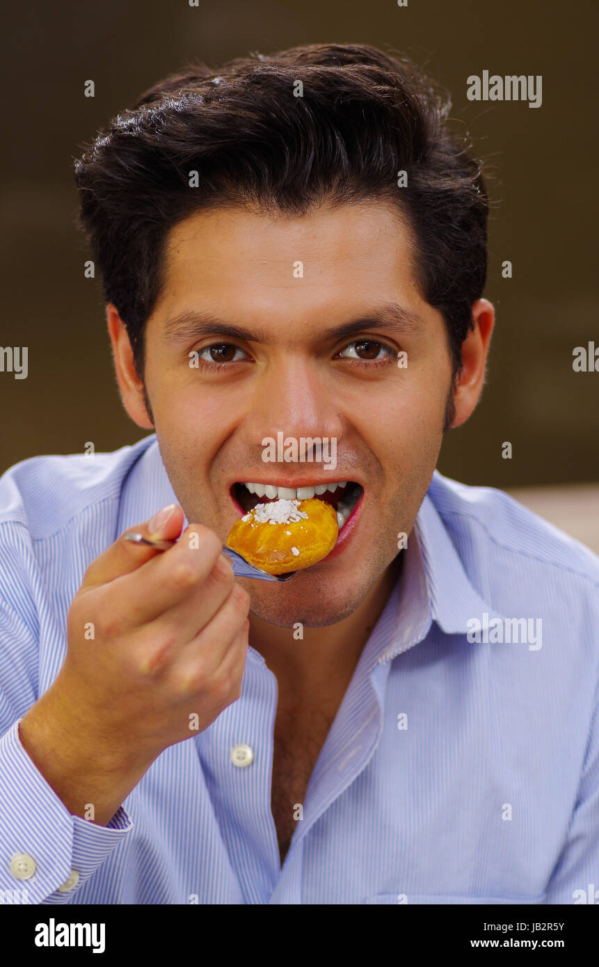 Handsome man eating a delicious turkish dessert sekerpare with coconut ...