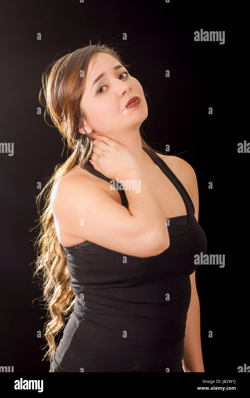 Beautiful young lady Suffer crick after workout in a black background ...