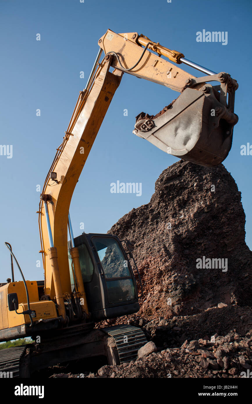 A large construction excavator of yellow color on the construction site ...