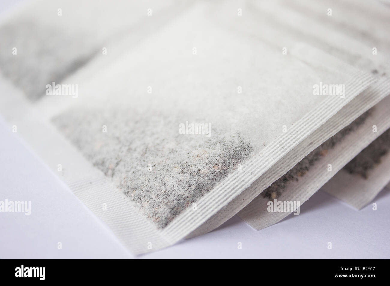 Multiple tea bags lying around on a white background Stock Photo - Alamy
