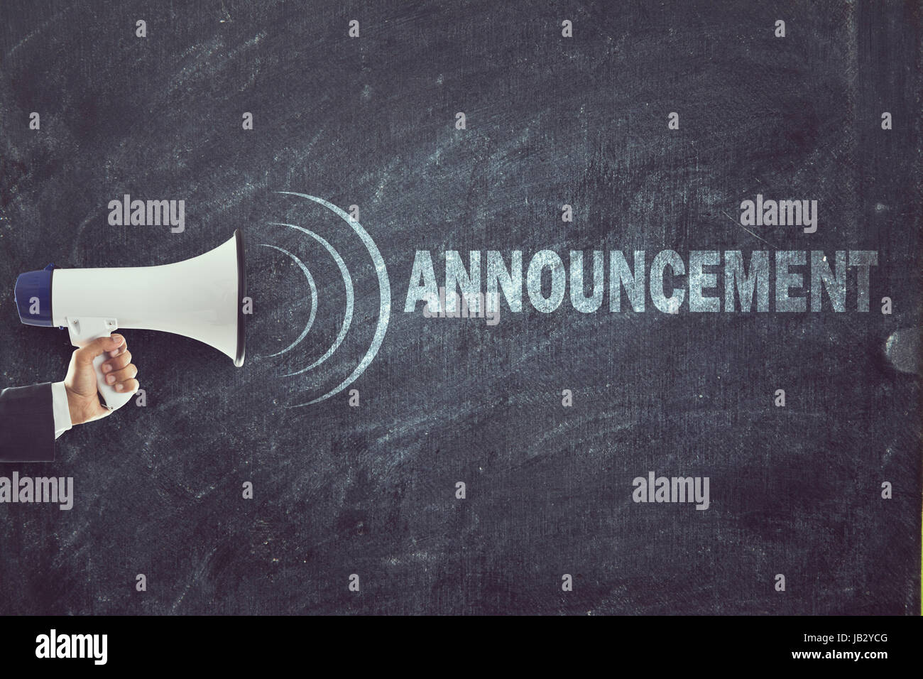 Man holding a megaphone in front of blackboard with announcement text ...