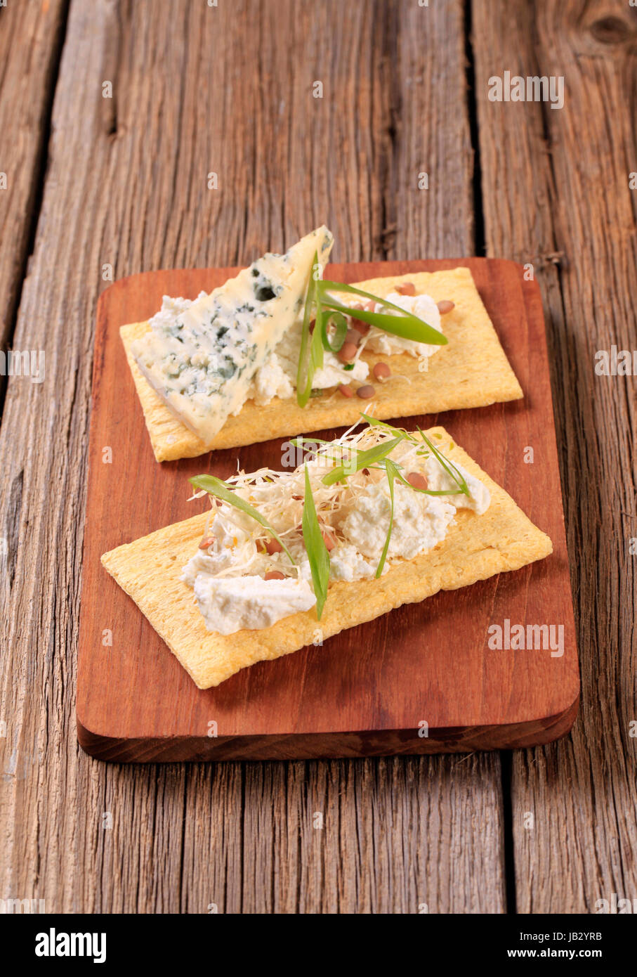 Two slices of corn crispbread with cheese toppings Stock Photo - Alamy
