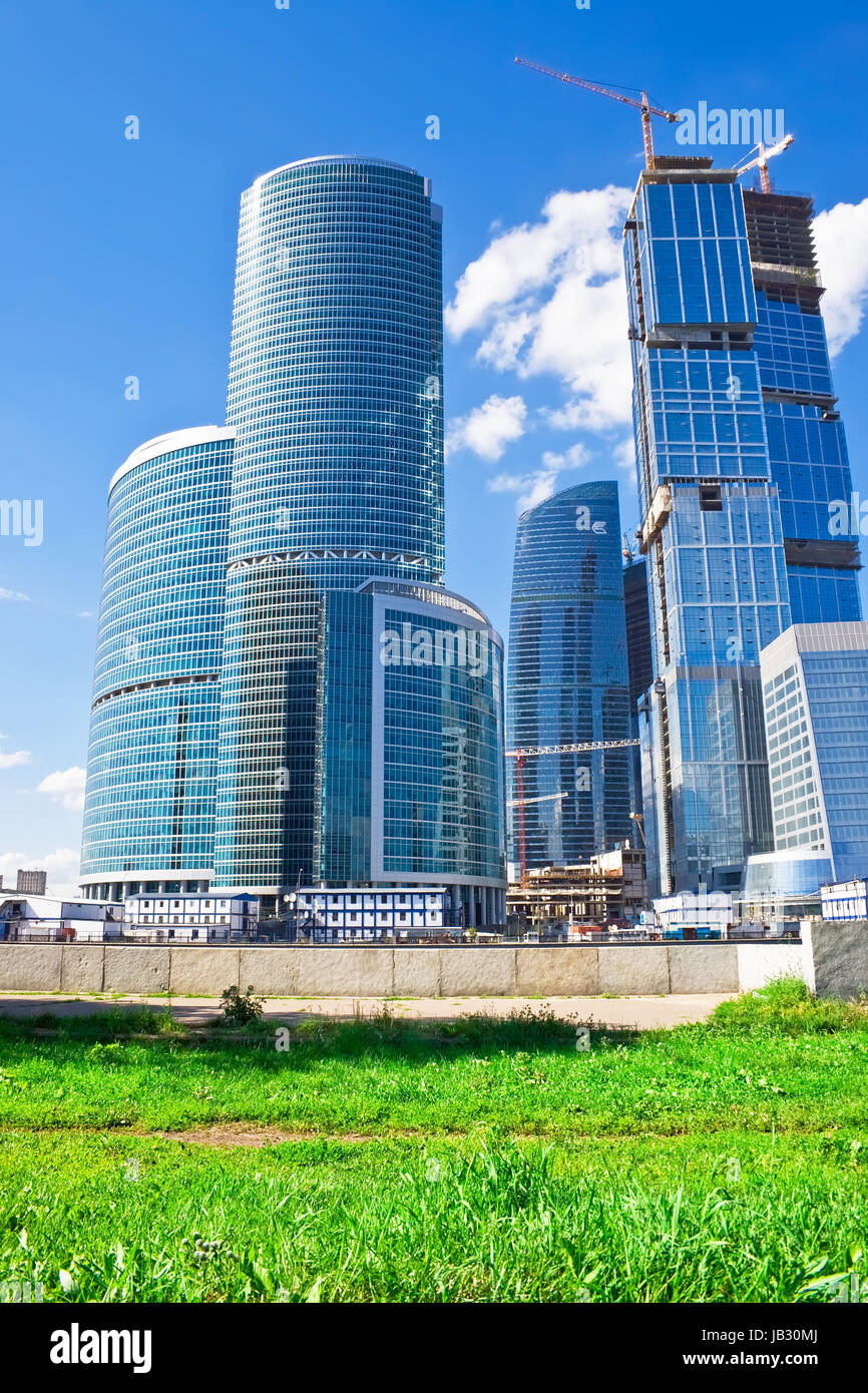 Construction of new skyscrapesrs and green grass Stock Photo - Alamy