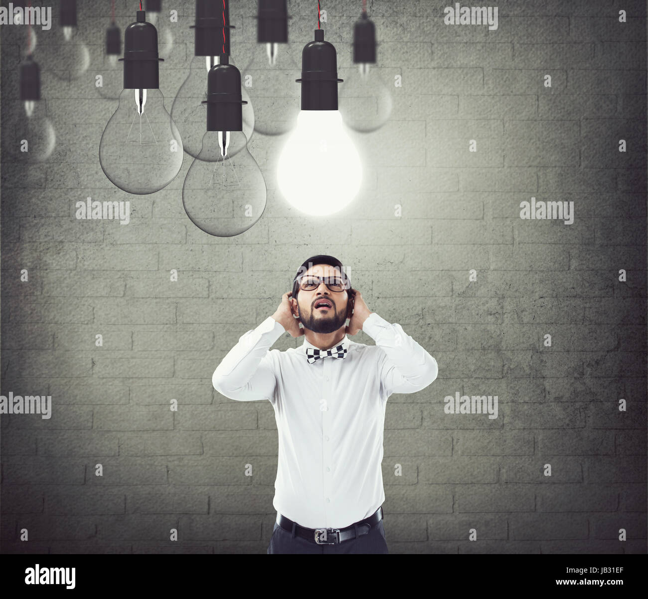 Businessman looking at glowing light bulb Stock Photo - Alamy