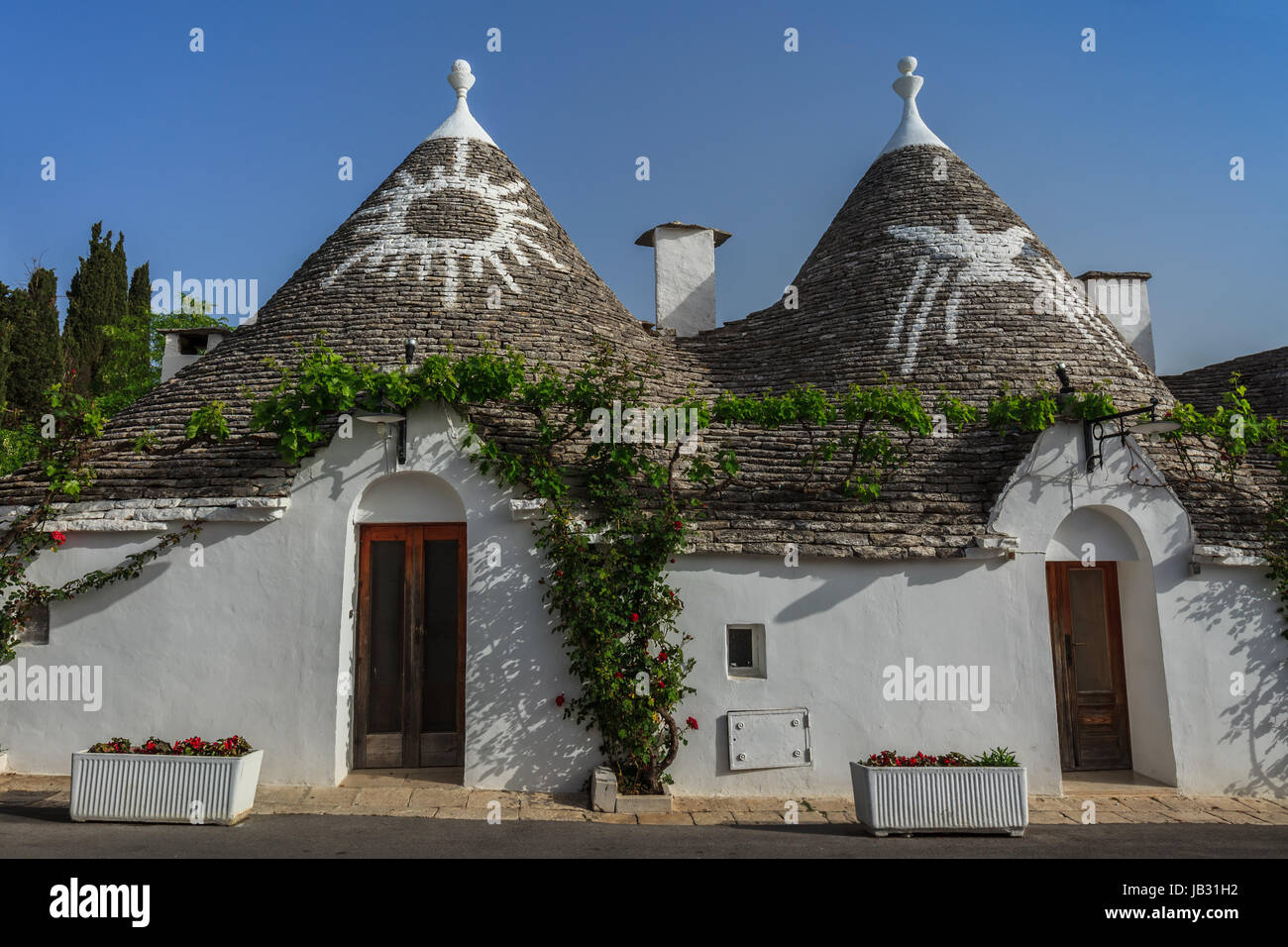 Trulli houses with painted symbols on the conical roofs in Alberobello ...