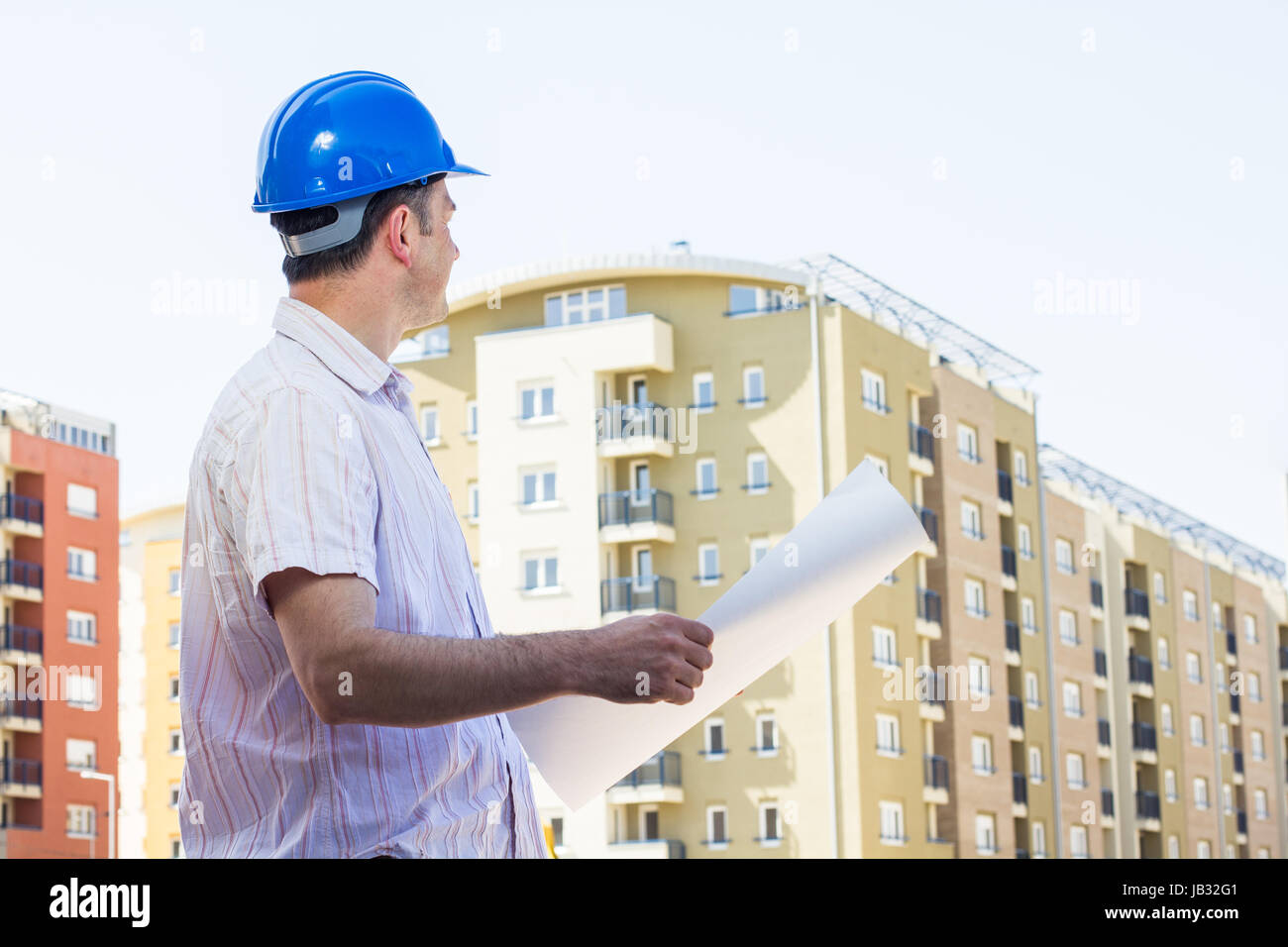 Construction manager holding project and observed on building site ...