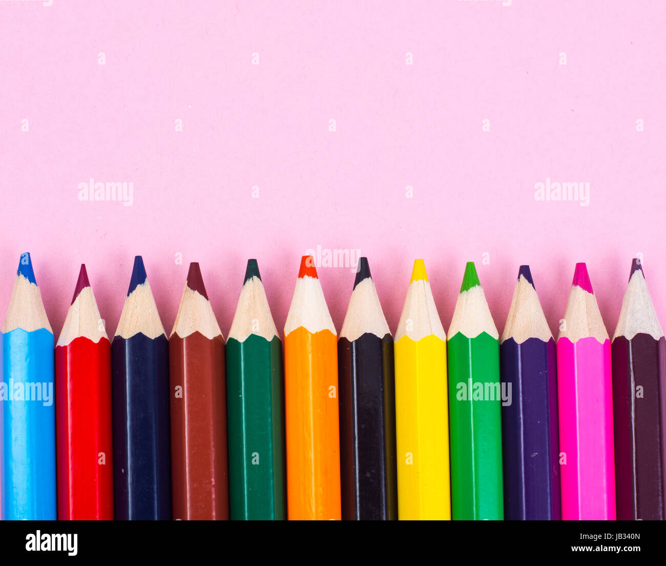 Multicolored pencils on pink paper background. Studio Photo Stock Photo ...