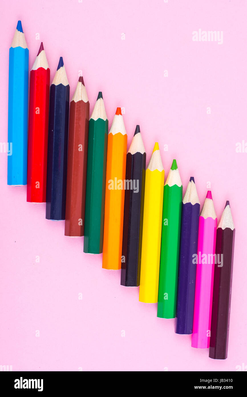 Multicolored pencils on pink paper background. Studio Photo Stock Photo ...