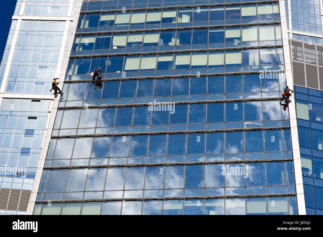 Two men cleaning windows of a skyscraper Stock Photo - Alamy