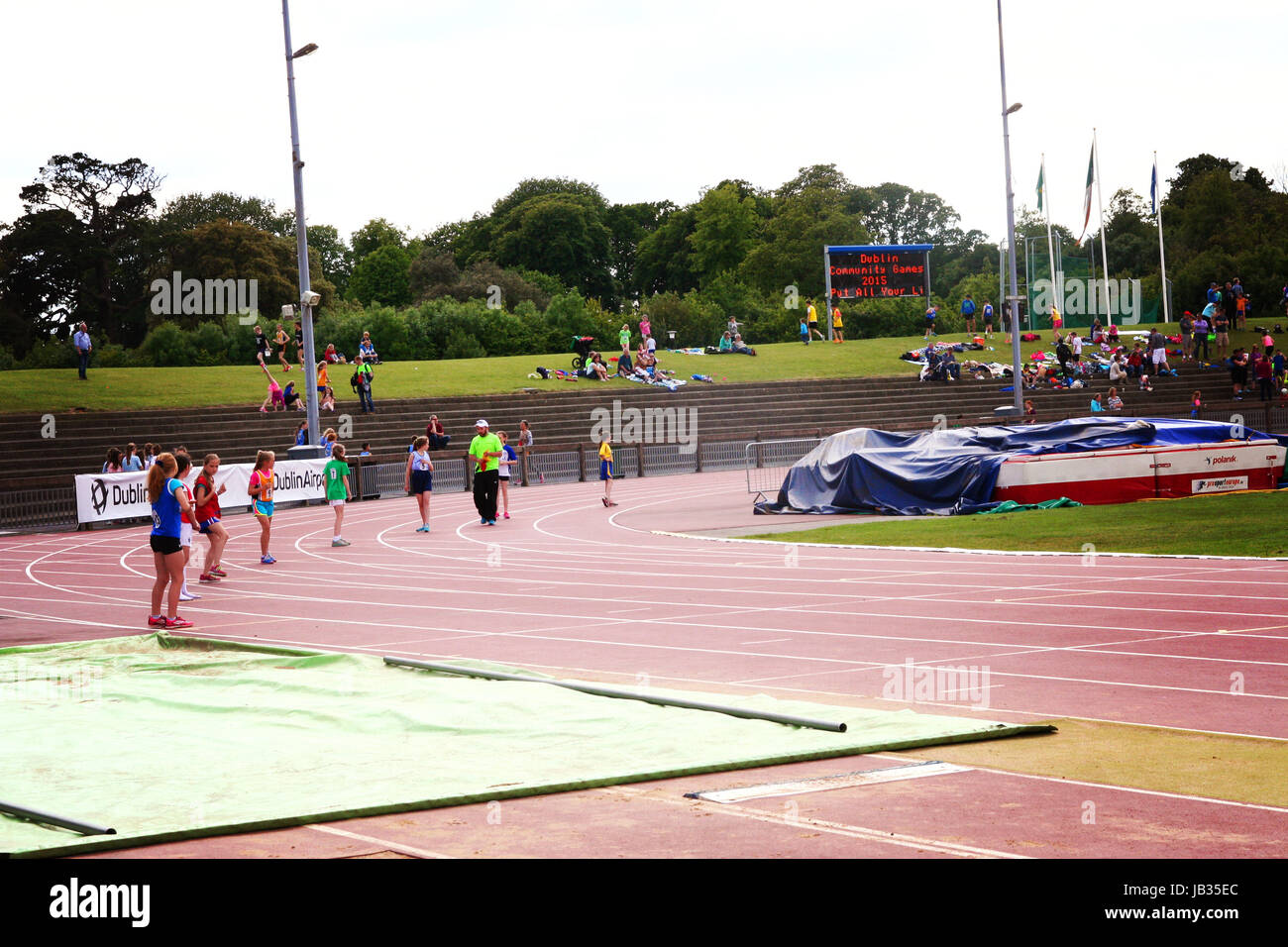 Girls lined up to run a race at an athletics track on an overcast day ...