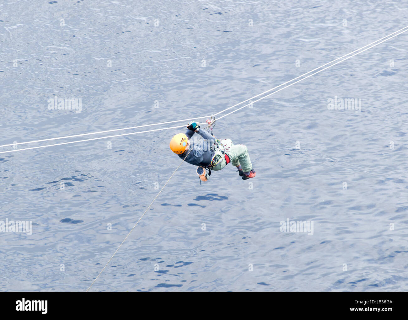 A male climber crosses a river via tyrolean traverse Stock Photo - Alamy