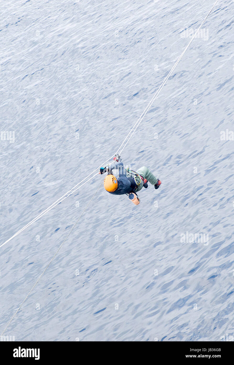 A male climber crosses a river via tyrolean traverse Stock Photo - Alamy
