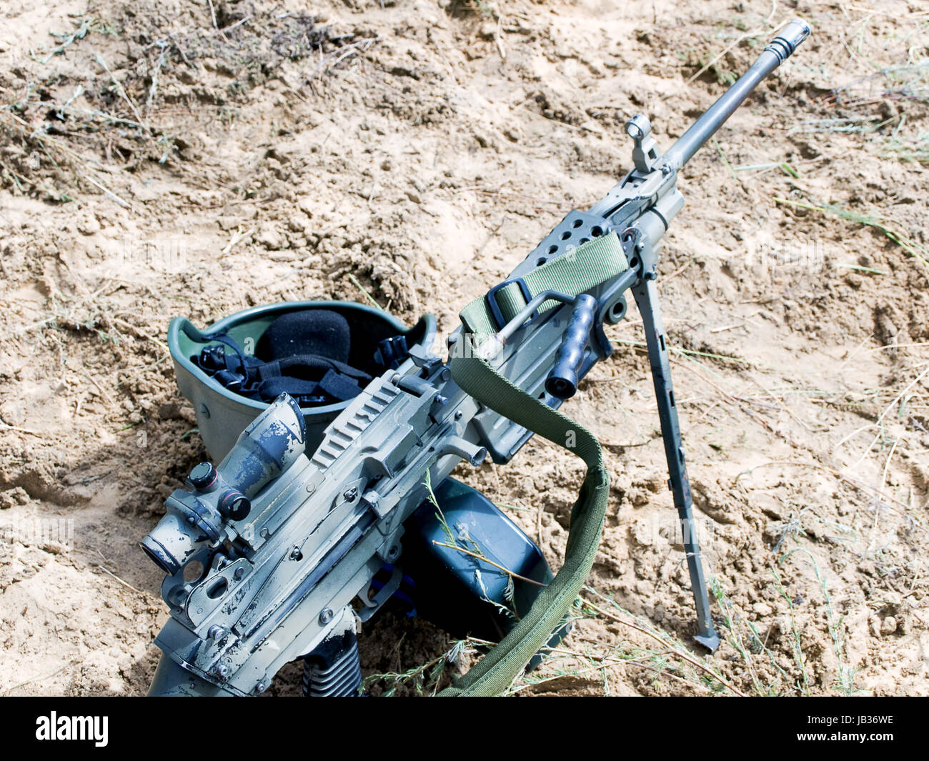 Soldier helmet and assault rifle on the sand Stock Photo - Alamy