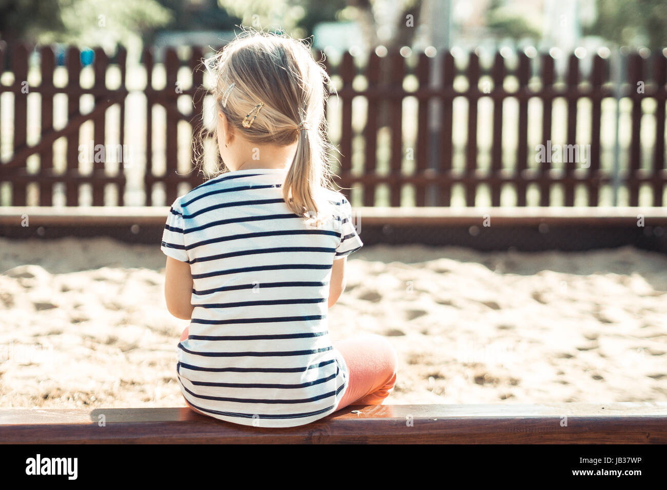 Little girl waiting alone at the playground Stock Photo - Alamy